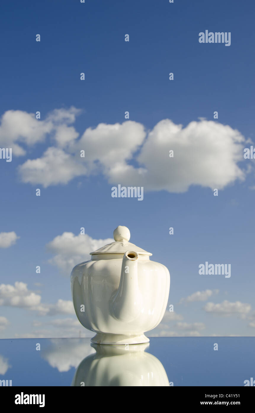 white teapot on mirror and sky background Stock Photo - Alamy