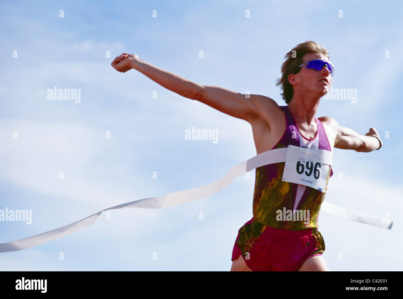 Male runner victorious at the finish line in a track race Stock Photo ...