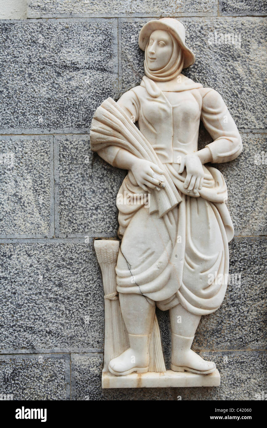 A traditional female farm worker is represented in bas relief on a wall ...