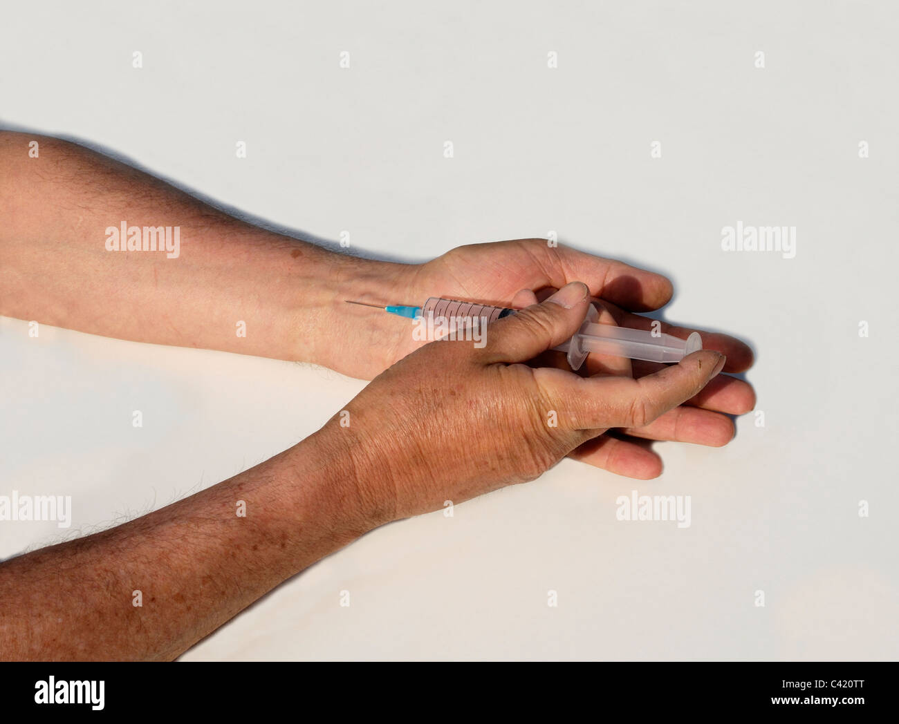Man injecting with a syringe into own arm. On white background Stock ...
