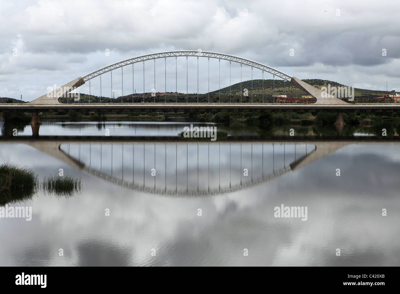 The arch of the Puente Lusitania bridge reflects in the Guadiana river ...