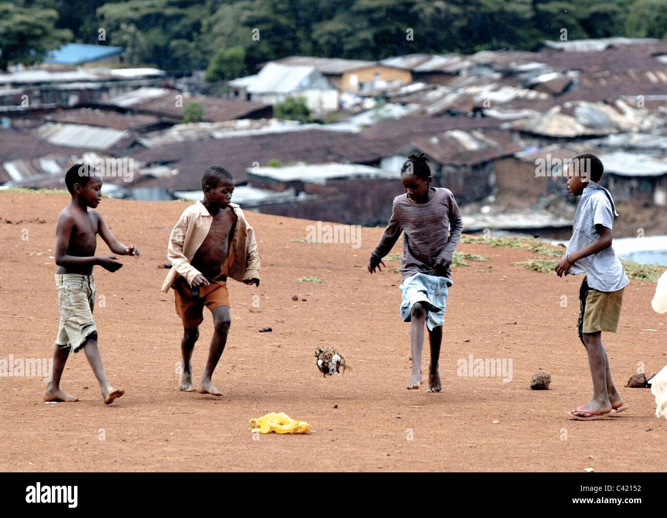 Children playing with a makeshift football in the Kenyan slum of ...