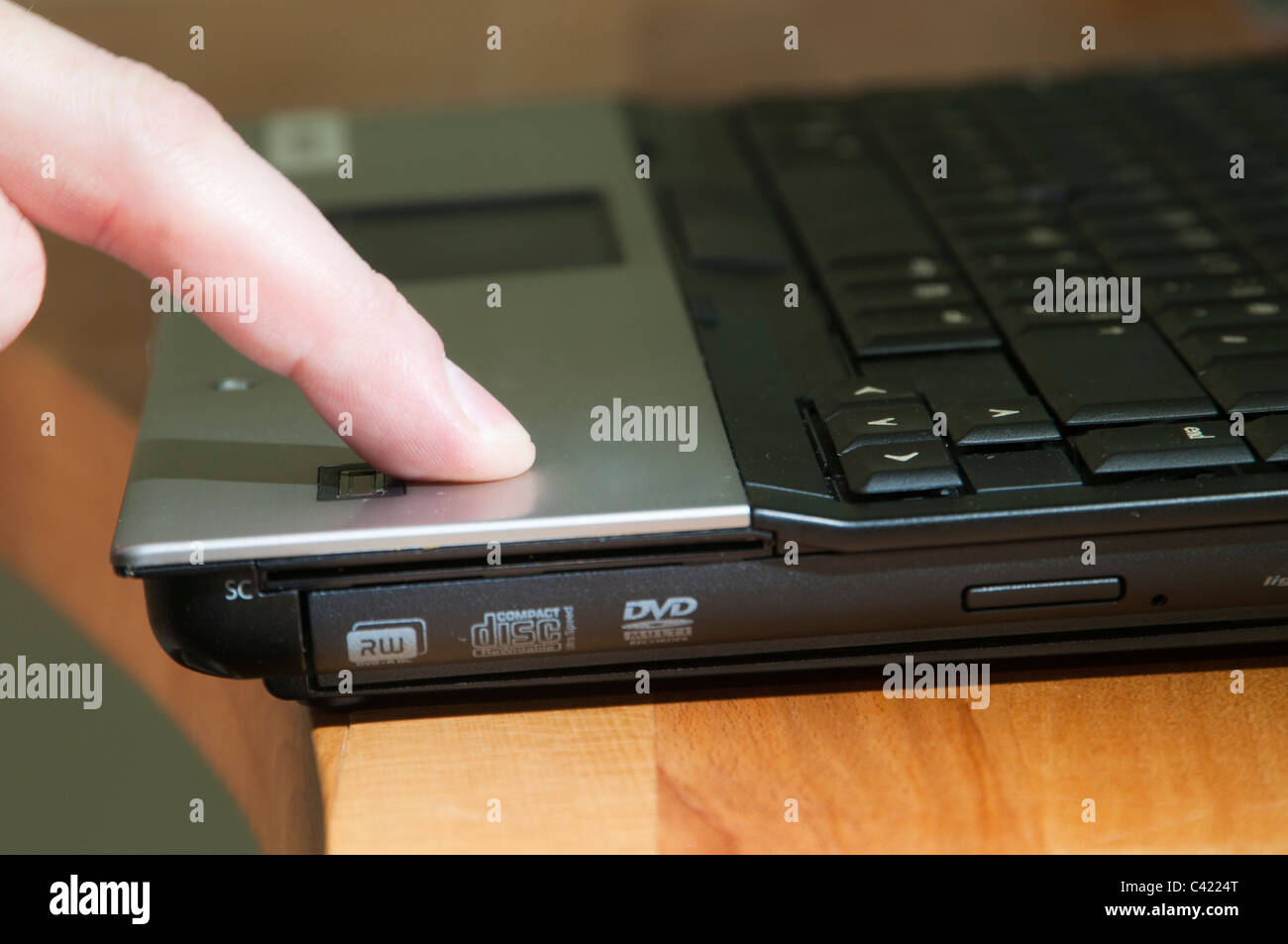 User swiping finger over finger print scanner on laptop Stock Photo - Alamy