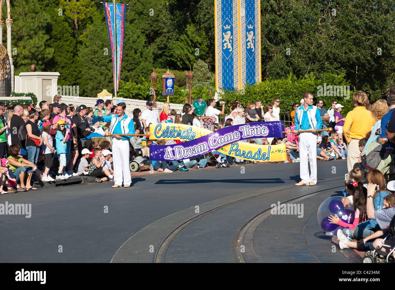 Cast members carry sign at the start of A Dream Come True parade at the ...