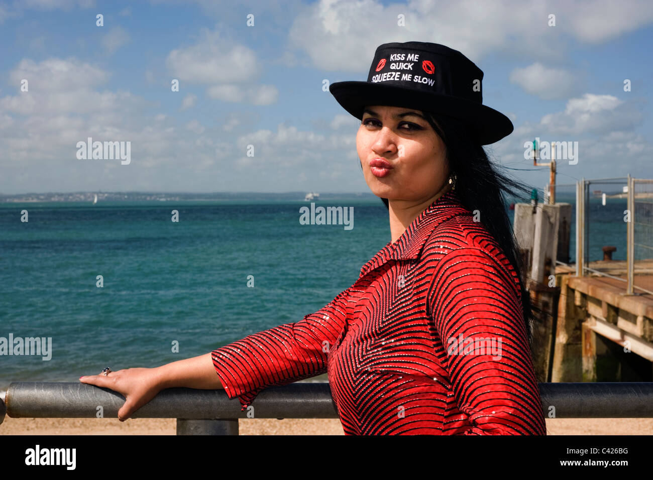 female holidaymaker at seaside wearing traditional kiss me quick hat ...