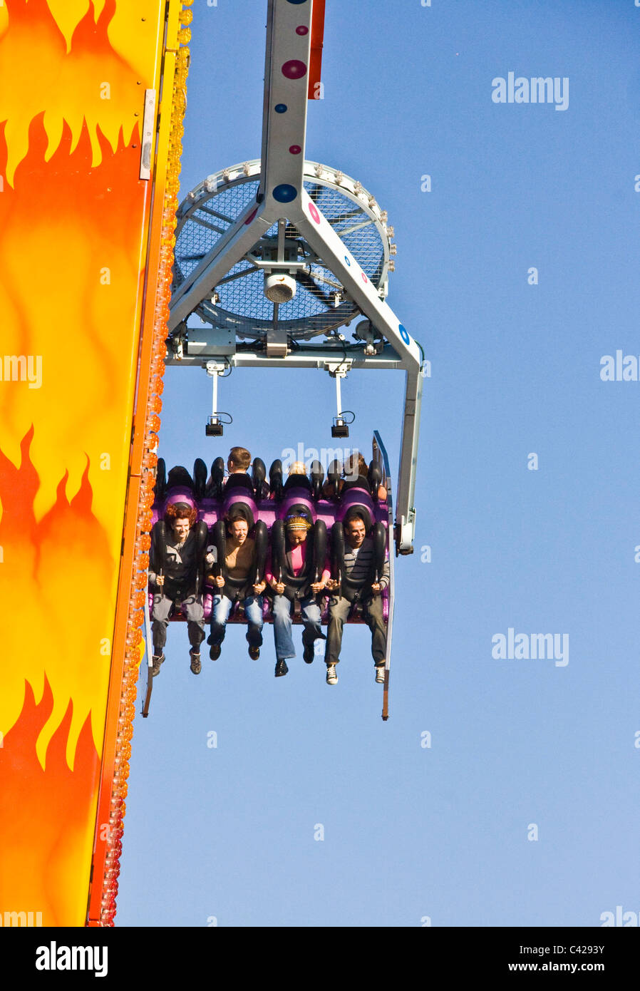 Fairground thrill ride in mid-air against clear blue sky Goose Fair ...