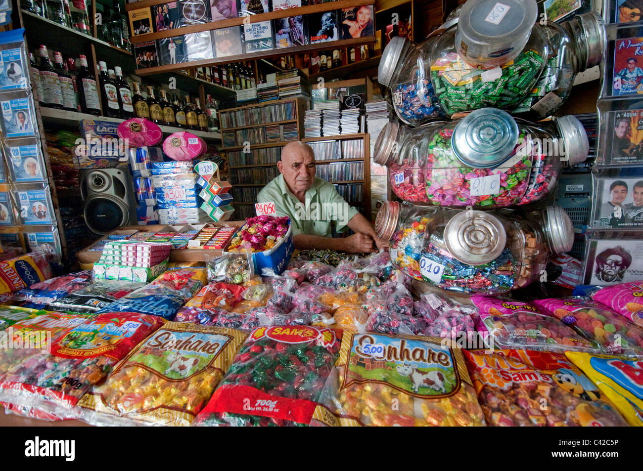Man selling sweets and candy in stall in a covered market in Recife ...