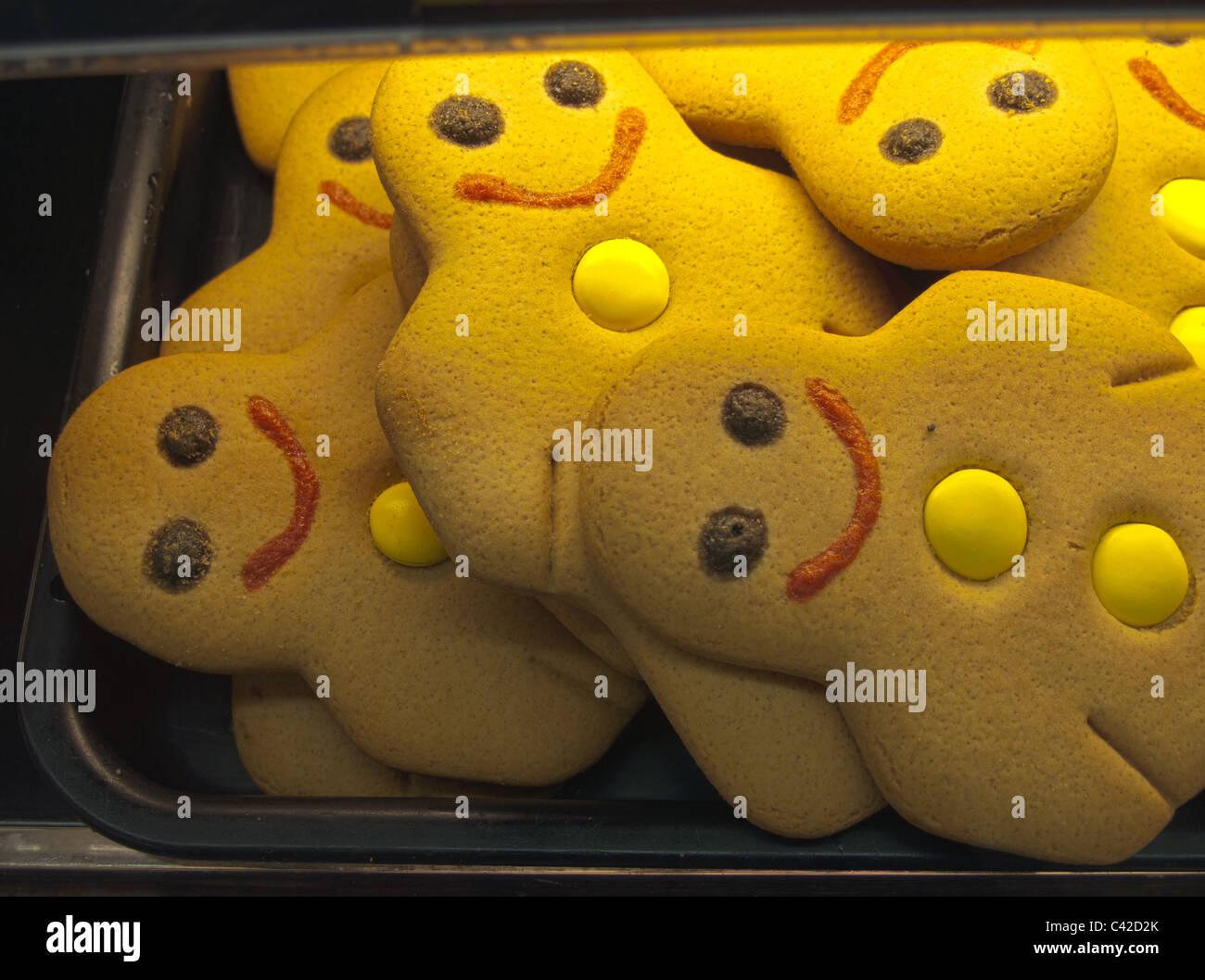 smiley gingerbread men in a baking tray after coming out of the oven ...