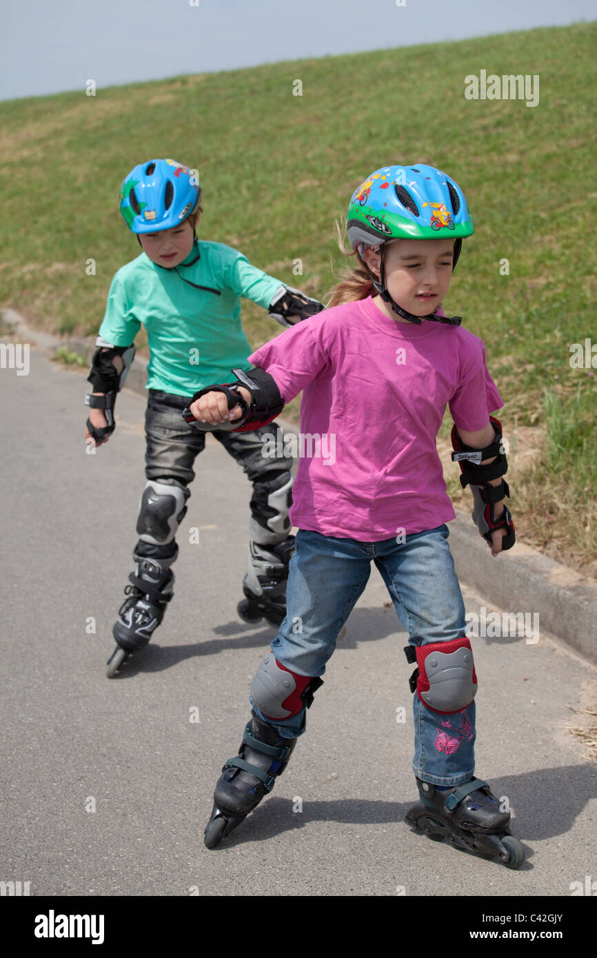 young brother and sister in-line skating together Stock Photo - Alamy