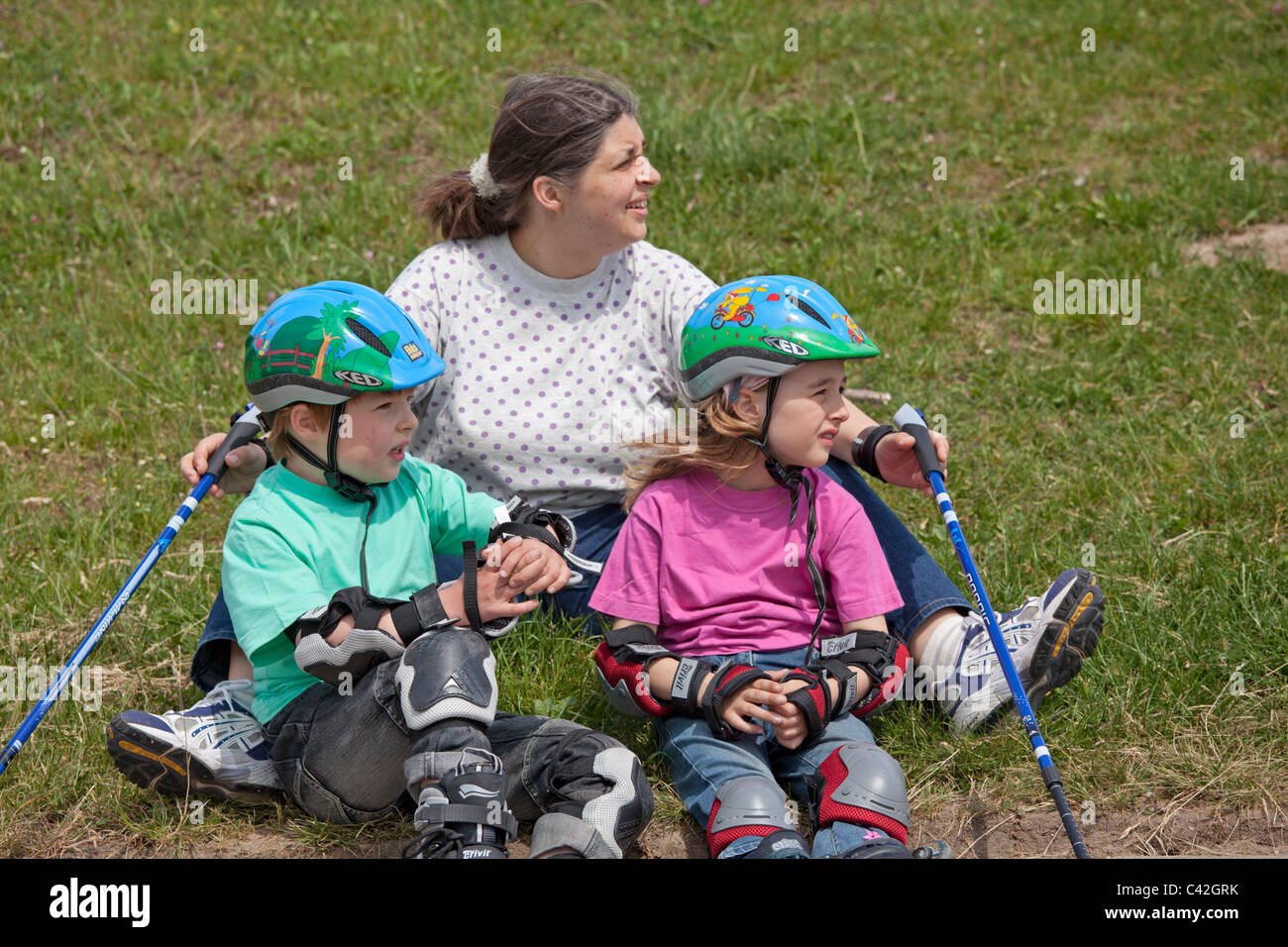 a middle-aged woman and her two young children having a break from ...