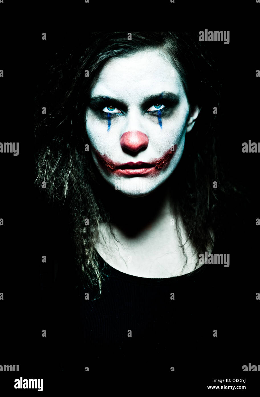 a scary female clown staring from the dark Stock Photo - Alamy