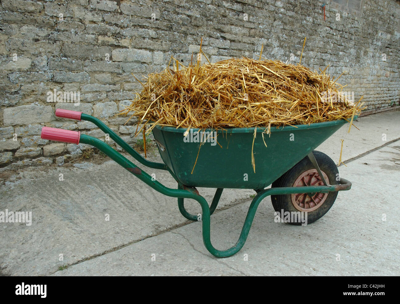 Wheelbarrow full of straw Stock Photo - Alamy