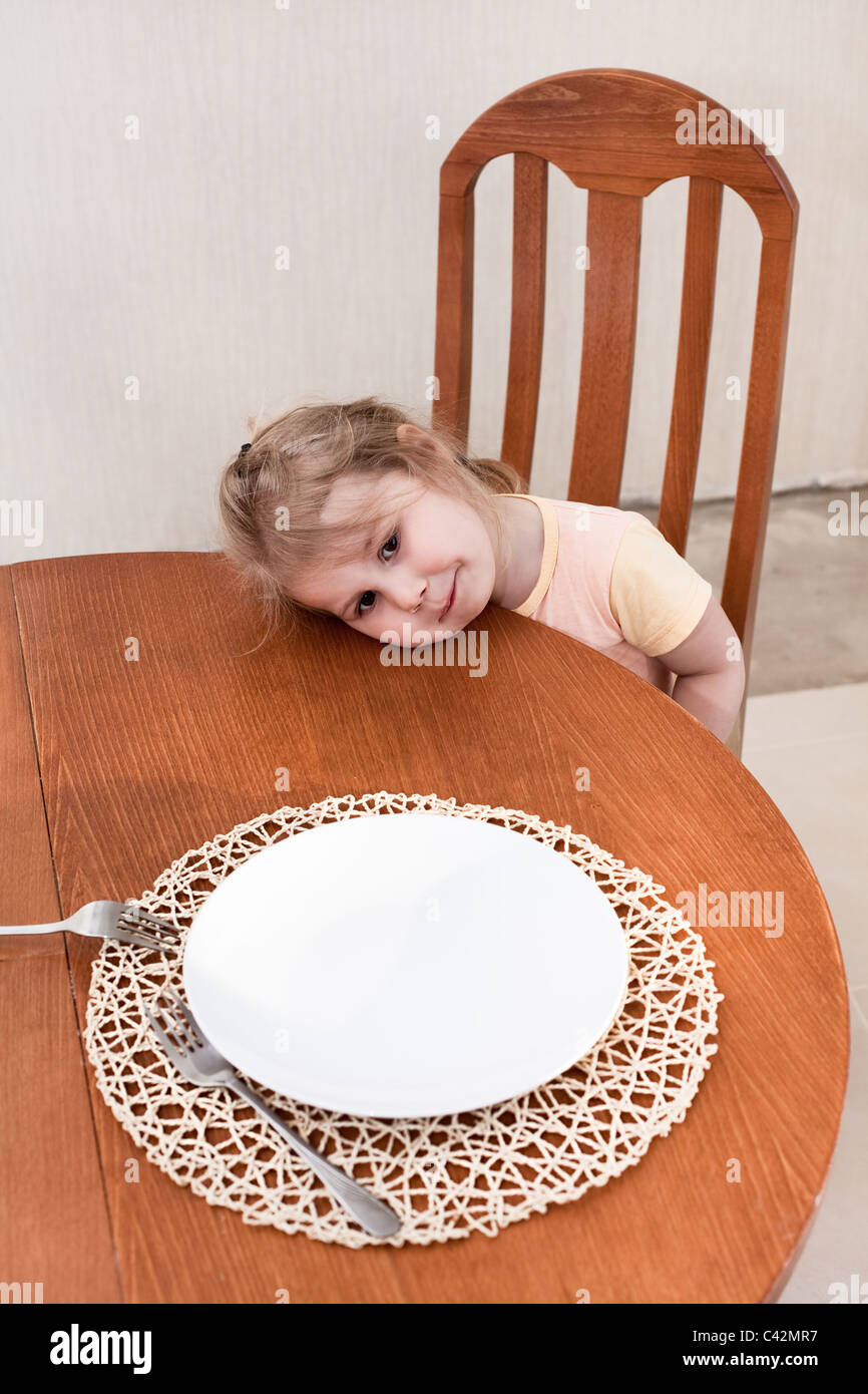 Little Russian child sitting along at table with empty plate Stock ...