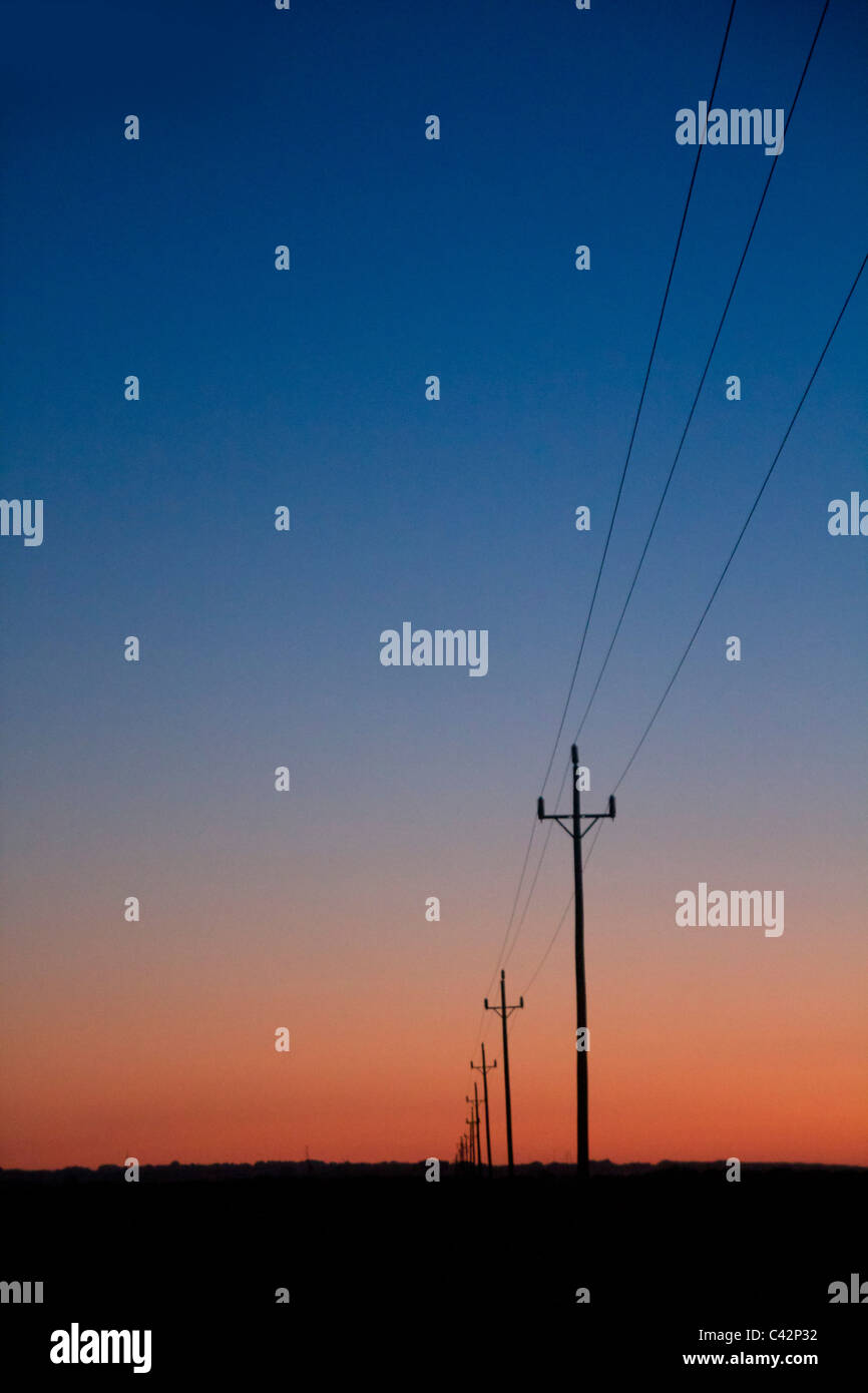 electric power lines in sunset blue red orange sunrise Stock Photo - Alamy