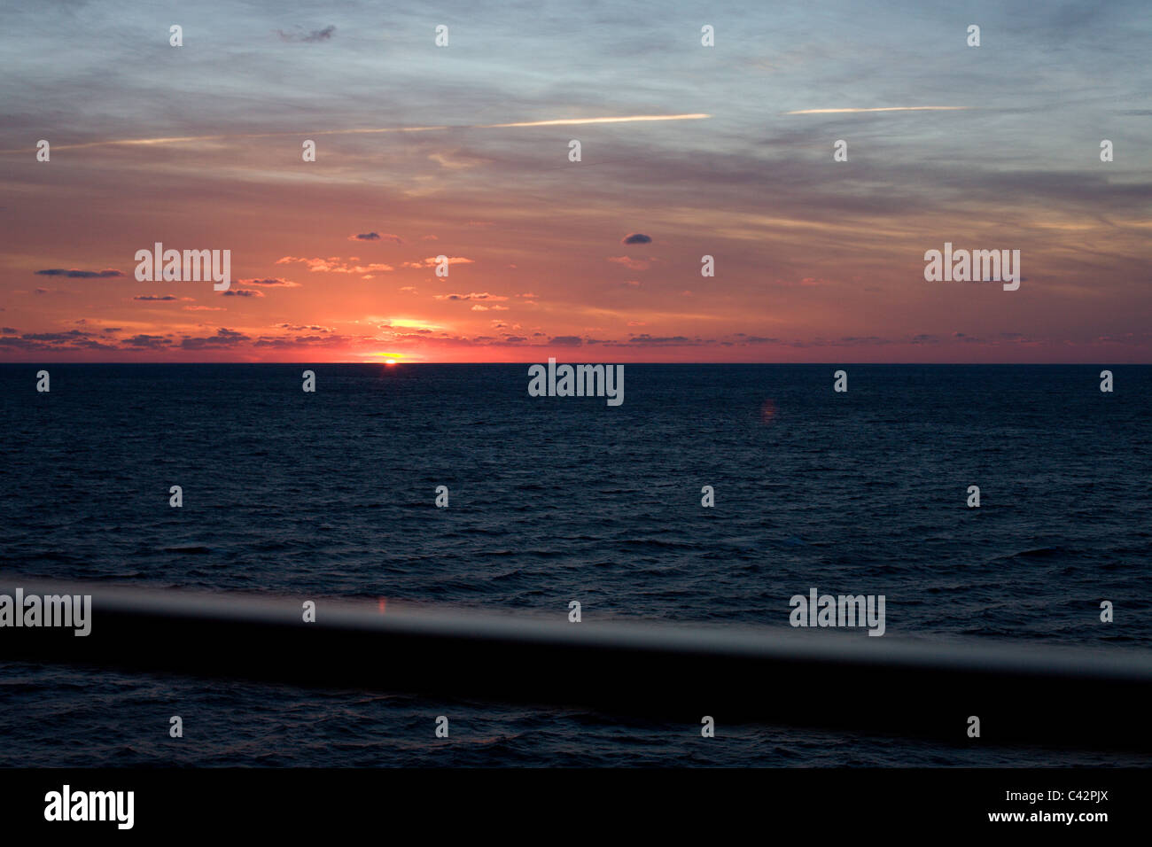 Sunset with railing in foreground Stock Photo - Alamy