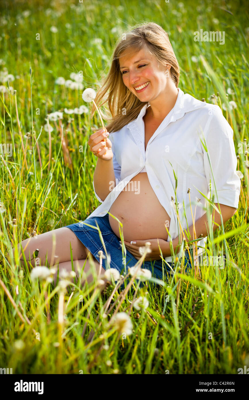 Pregnant woman outdoor at spring time on the green field Stock Photo ...