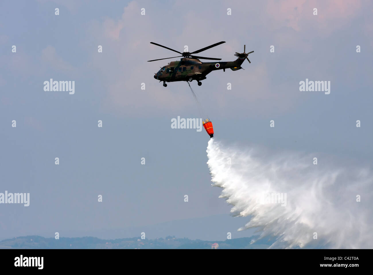 Military helicopter spraying water for damping fire Stock Photo - Alamy
