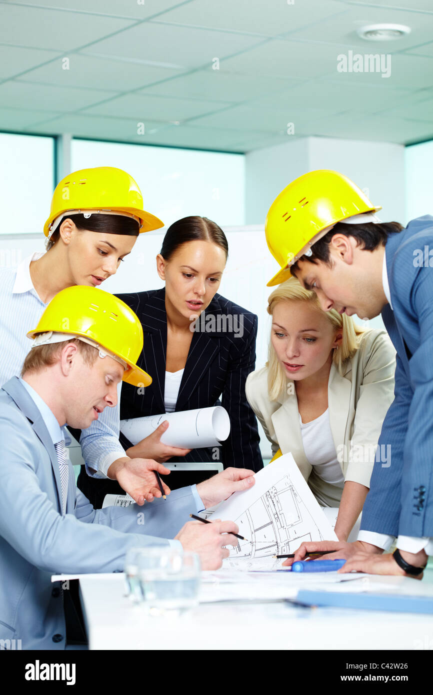Group of architects looking at a project and discussing it Stock Photo ...