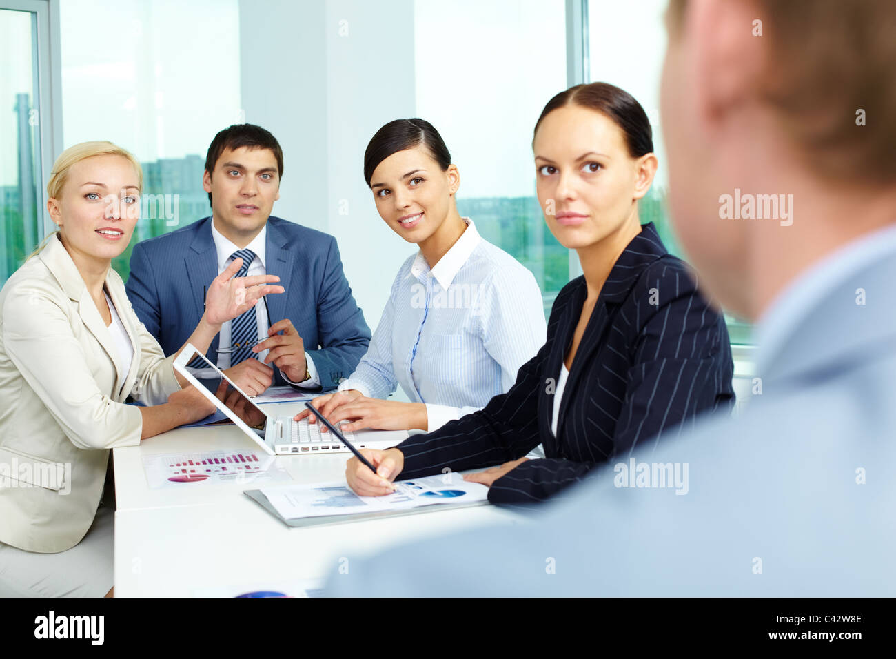 Group of business people looking at their employer while consulting in ...