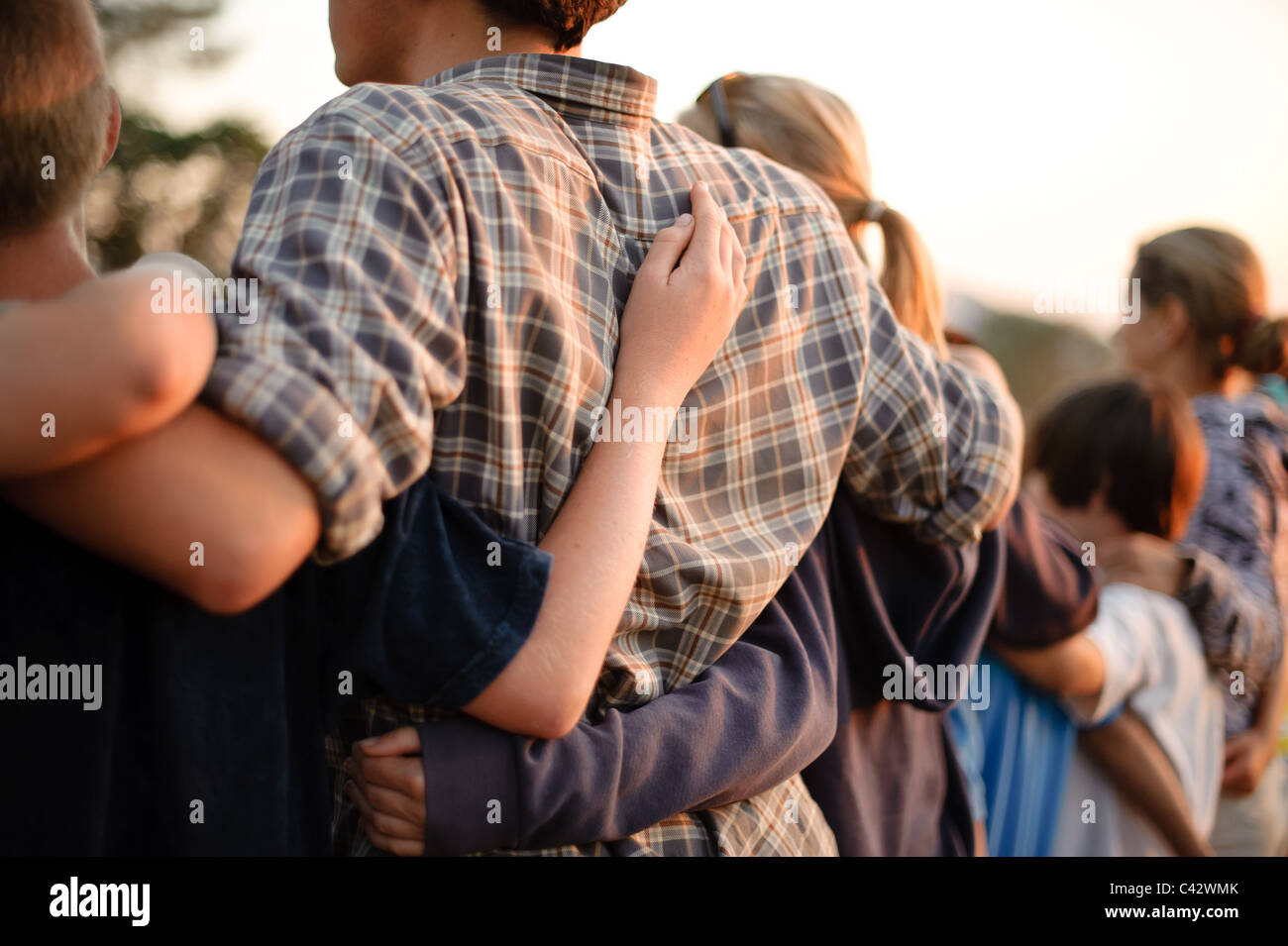 Friends link arms at sunset Stock Photo - Alamy
