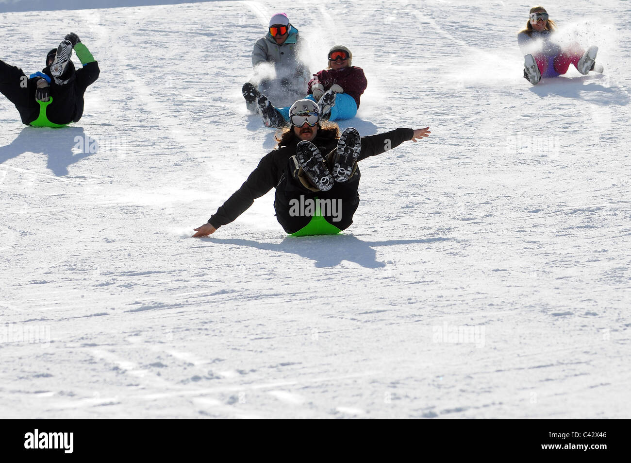 A group of friends sledge down a slope in the French Alps Stock Photo ...