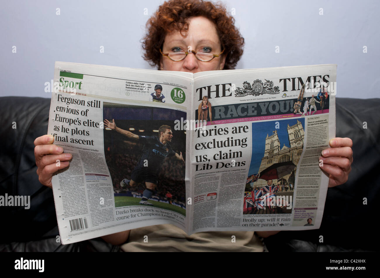 Woman reading a copy of the Times newspaper Stock Photo - Alamy