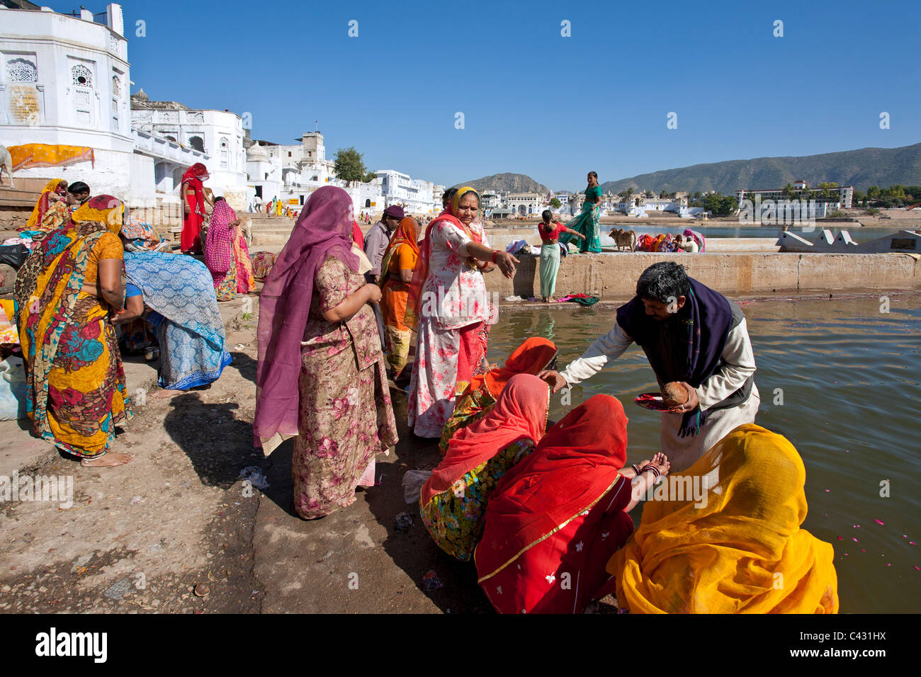 Indian women making a ritual offering (puja). Pushkar Lake. Rajasthan ...