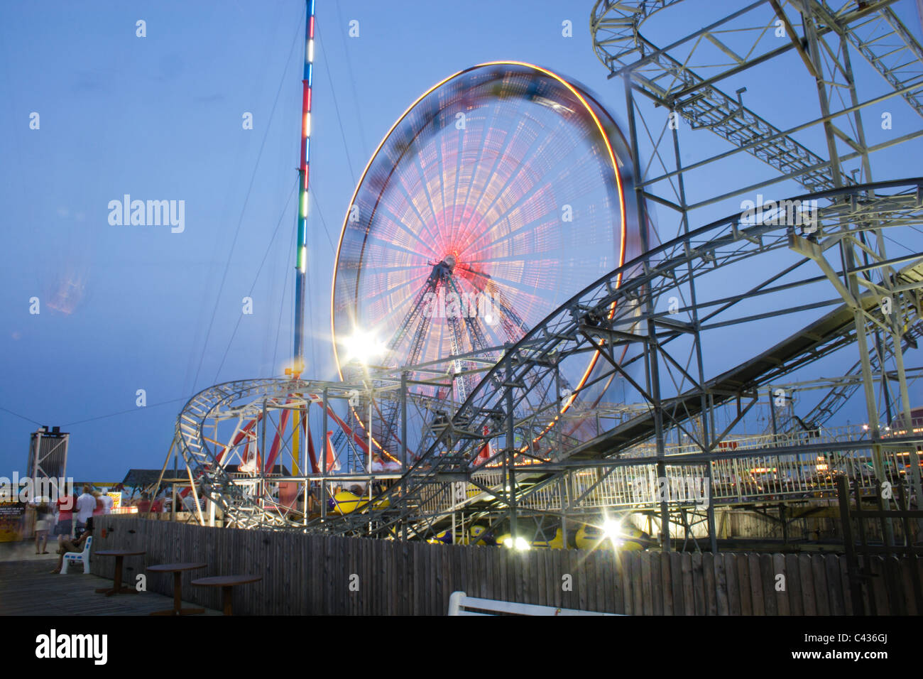 Fair at night, with ferris wheel and other rides Stock Photo - Alamy