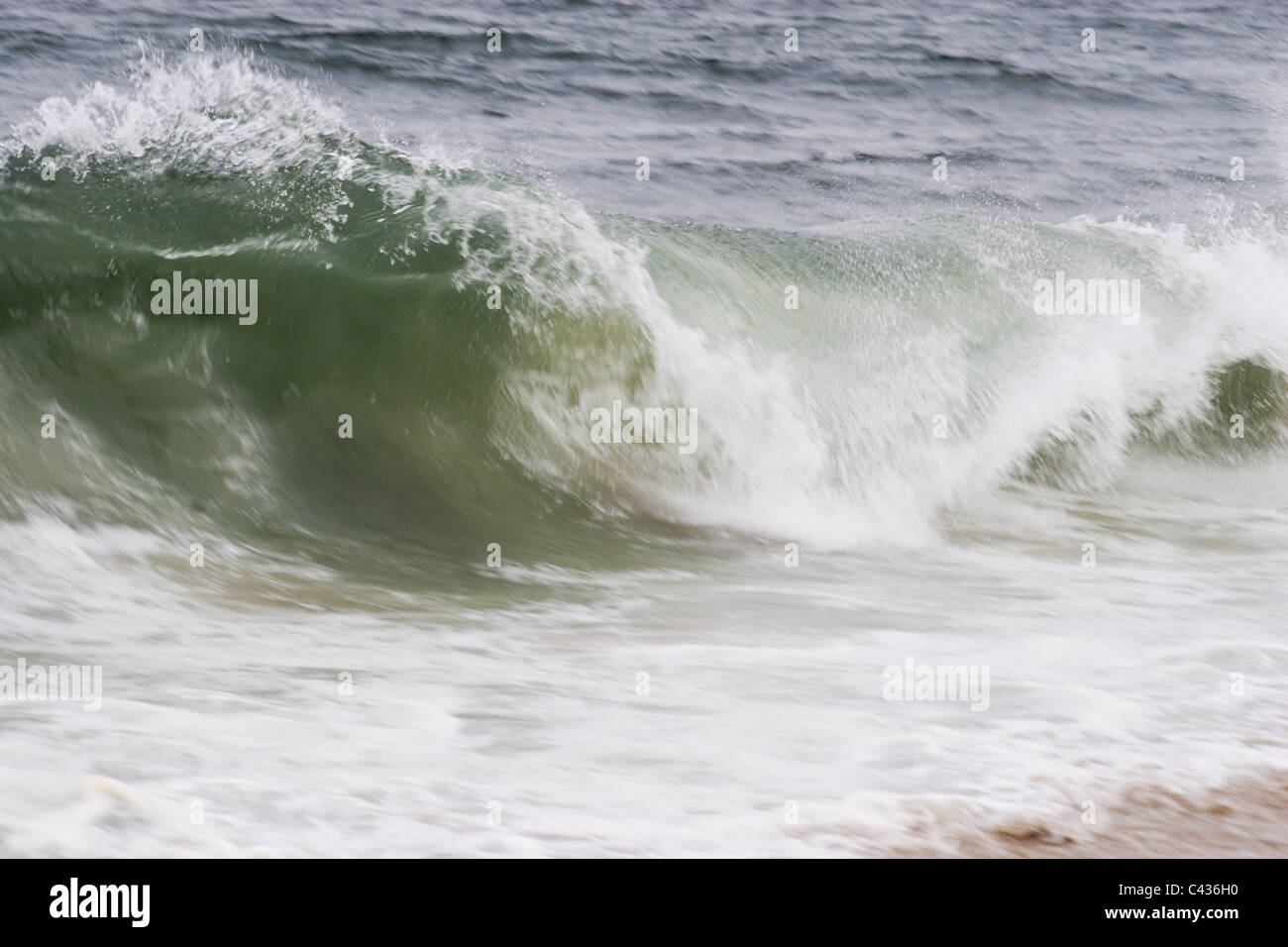 An ocean wave crashing on the shore Stock Photo - Alamy