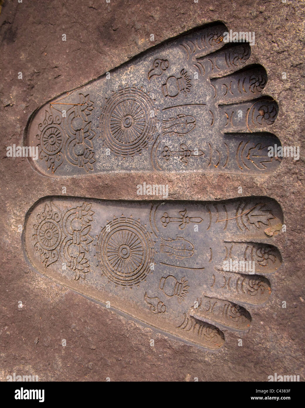 Foot imprints carved into ceremonial rock at temple Stock Photo - Alamy