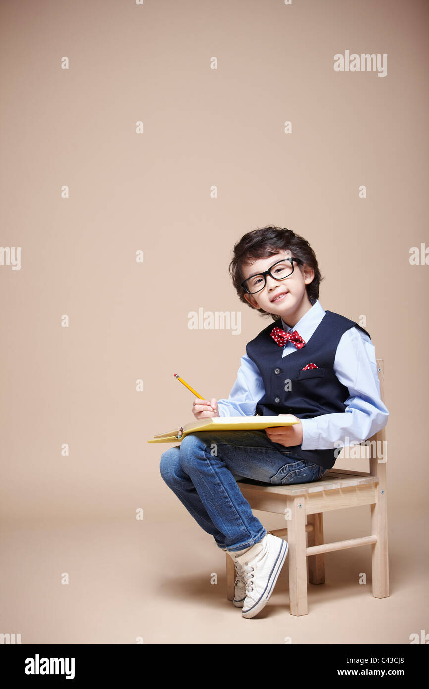 boy studying on chair Stock Photo - Alamy