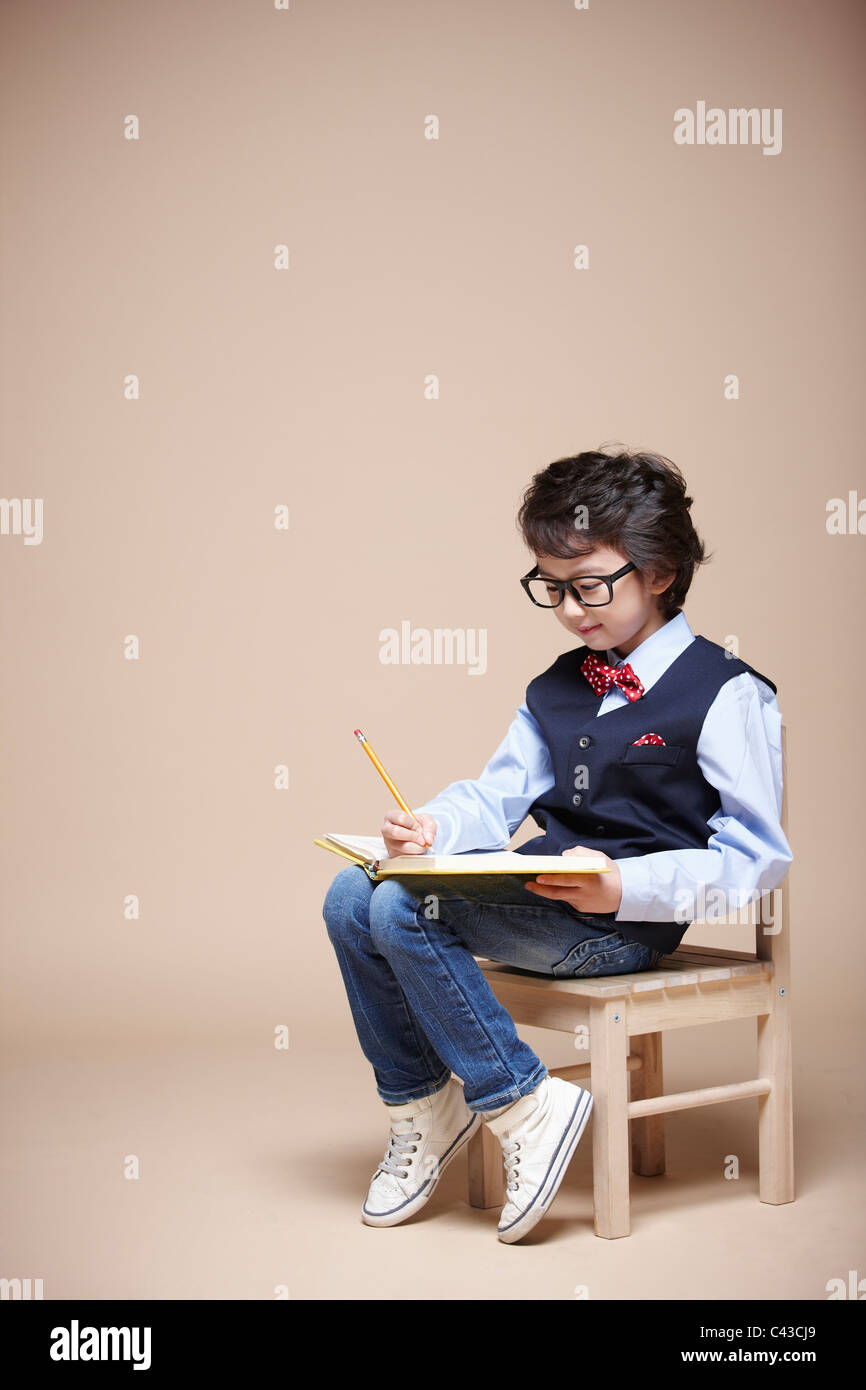 boy studying on chair Stock Photo - Alamy