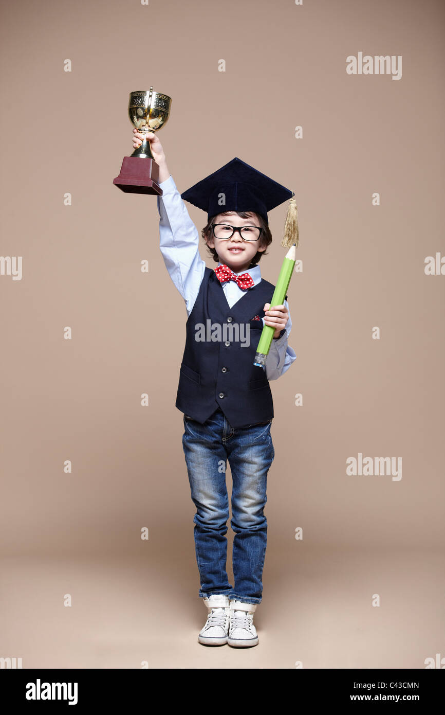 boy pick up the trophy wearing graduation cap Stock Photo - Alamy