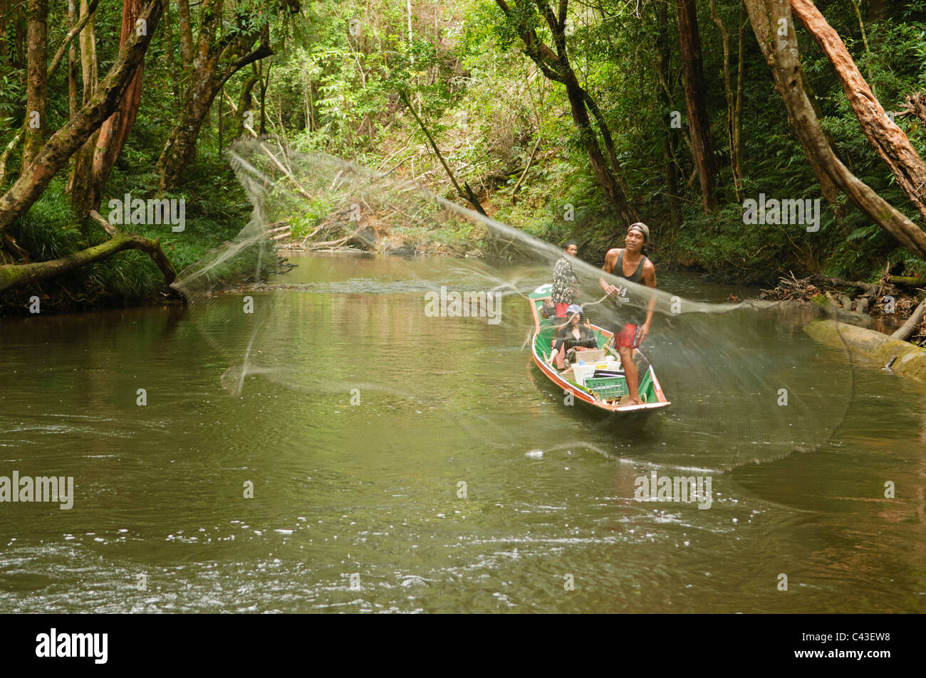Iban man casts his fishing net in Batang Ai National Park in Sarawak ...