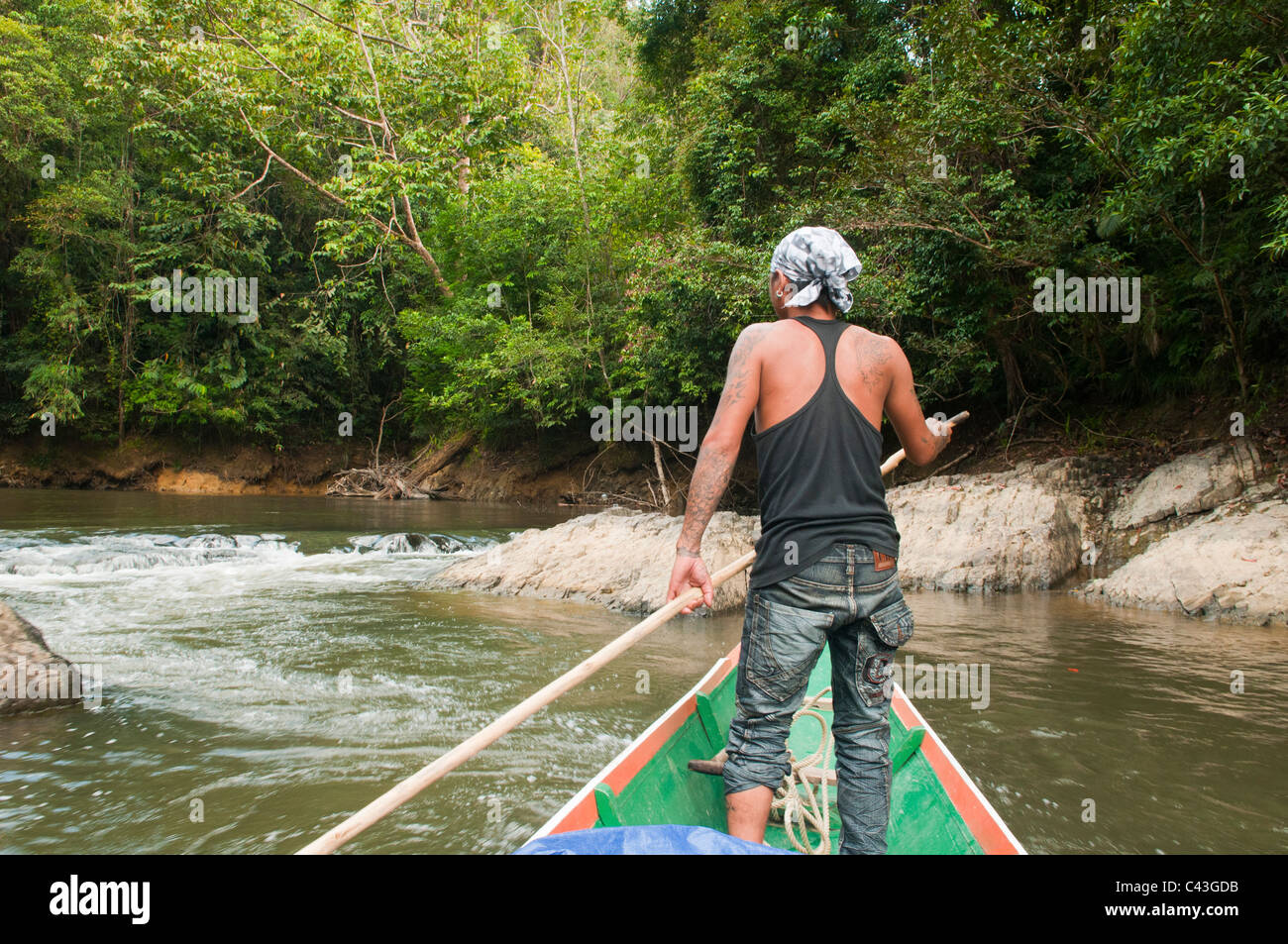 Iban man navigating the river in Batang Ai National Park in Sarawak ...