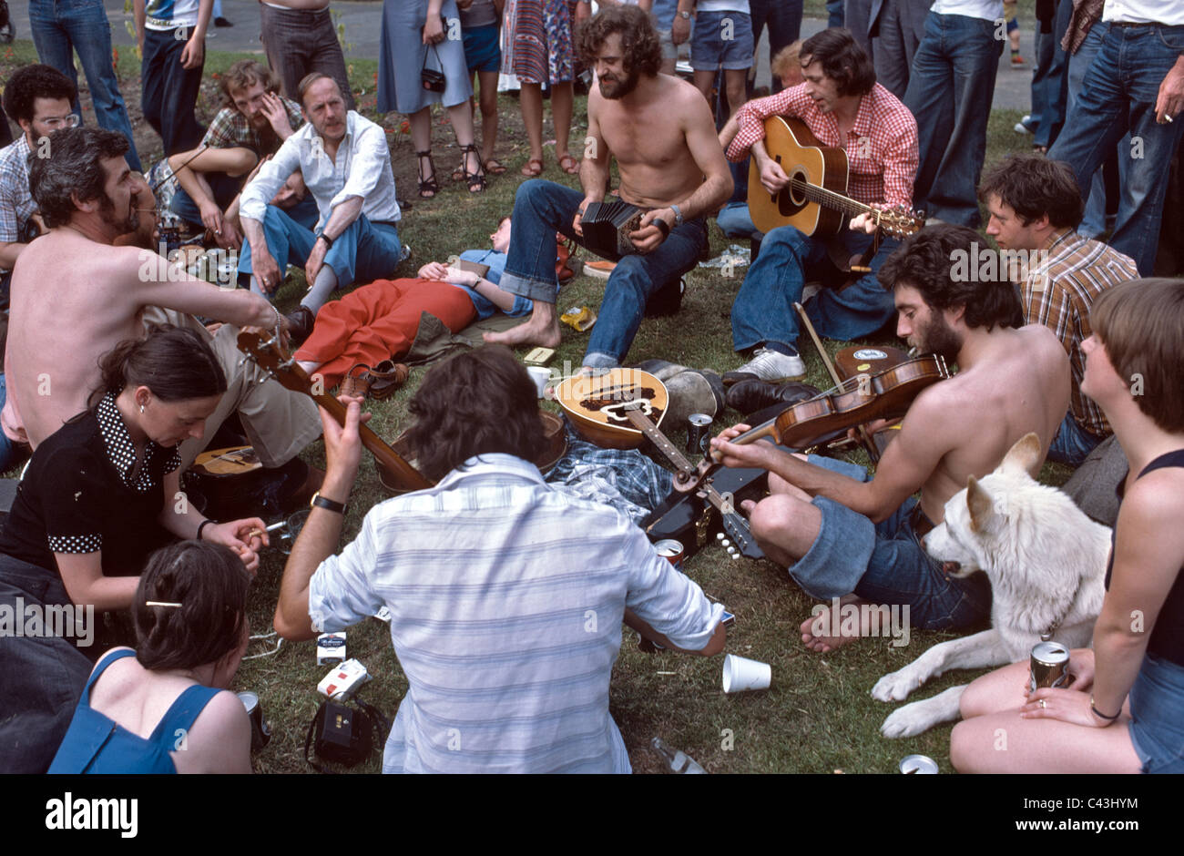 historical shot of outdoor festival with people playing string ...