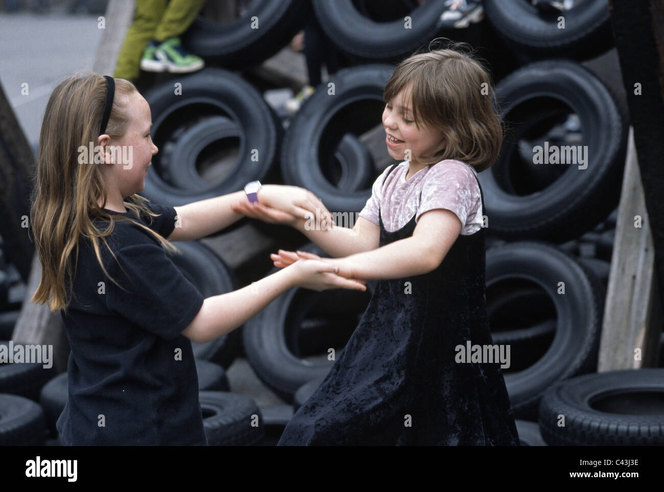 primary school girls playing a game with their hands in the playground ...