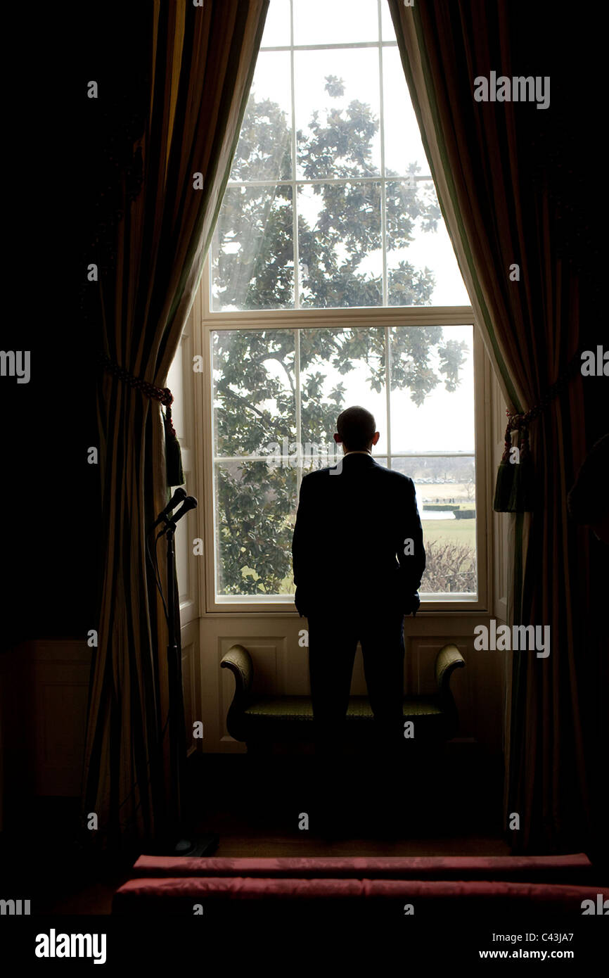 US President Barack Obama looks out the window of the White House Stock ...