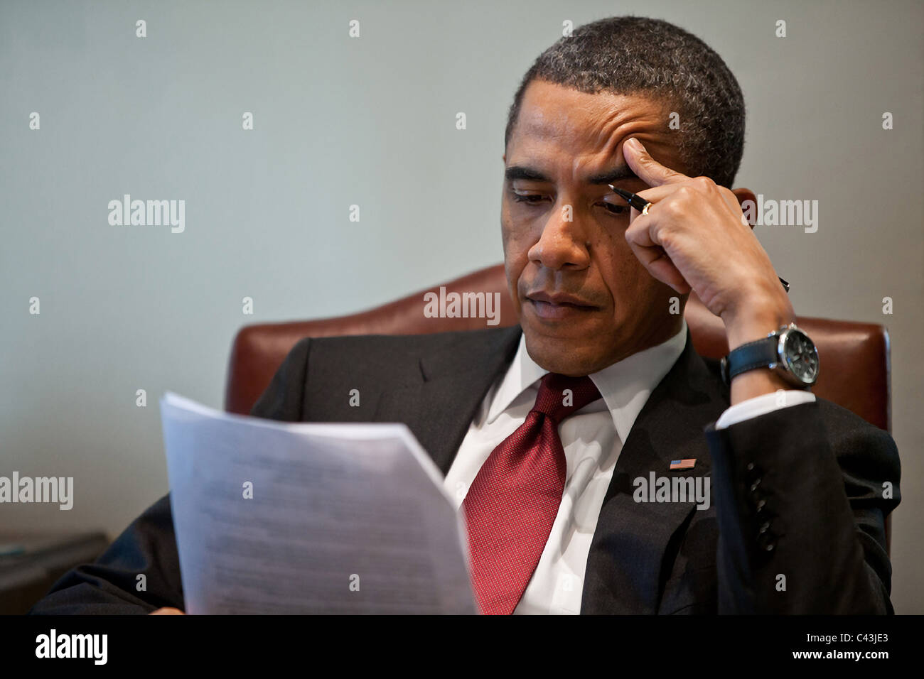 President Barack Obama reads a document in the Outer Oval Office Stock ...