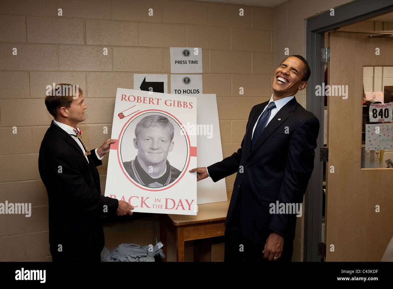 President Barack Obama laughs at a picture of a younger Press Secretary ...