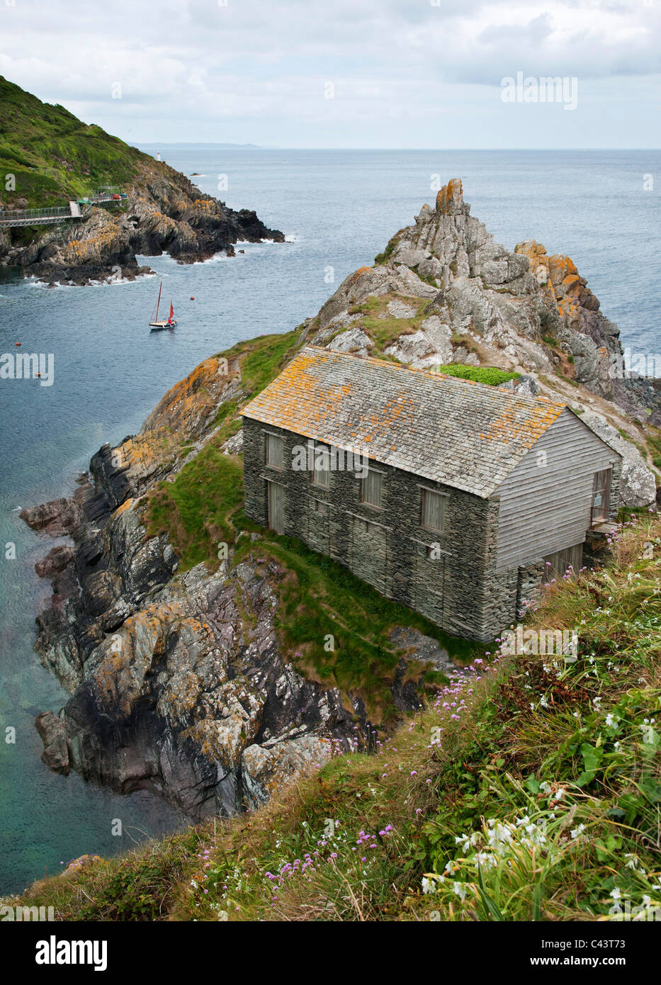 Old net loft at entrance to harbour of fishing village of Polperro ...