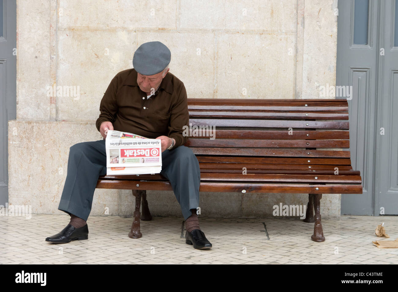 Old man reading newspaper on a public bench Stock Photo - Alamy