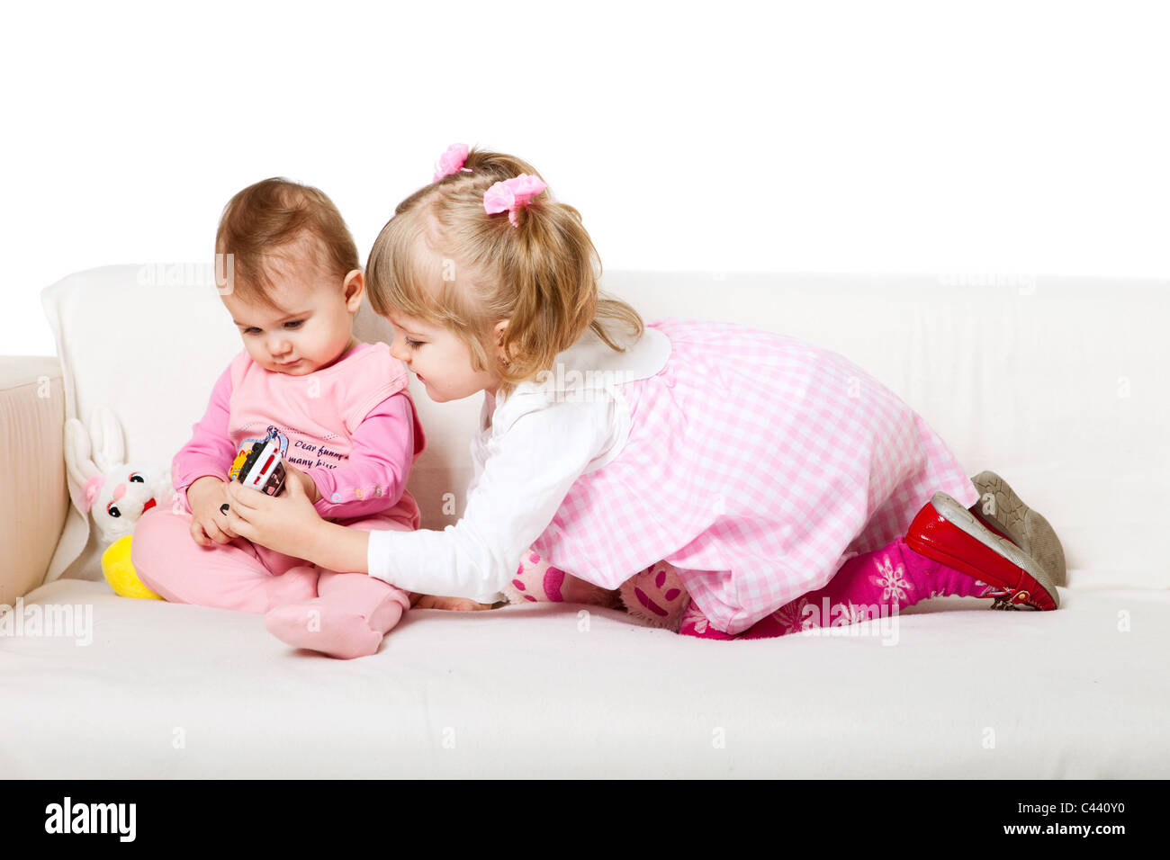 two adorable kids sitting on the sofa Stock Photo - Alamy
