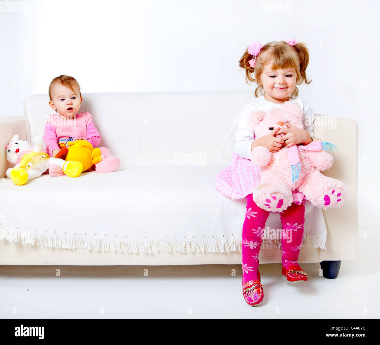 two adorable kids sitting on the sofa Stock Photo - Alamy