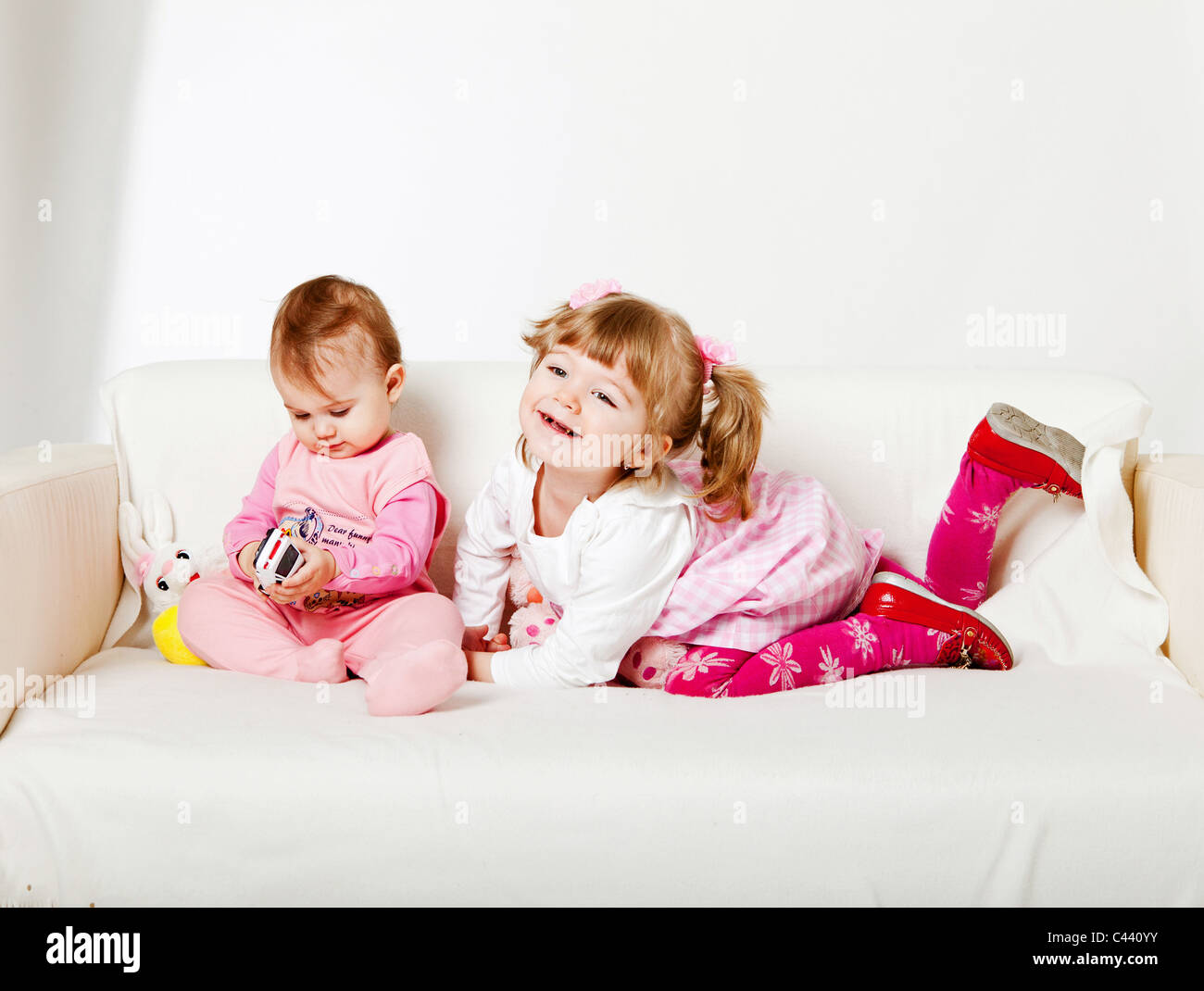 two adorable kids sitting on the sofa Stock Photo - Alamy