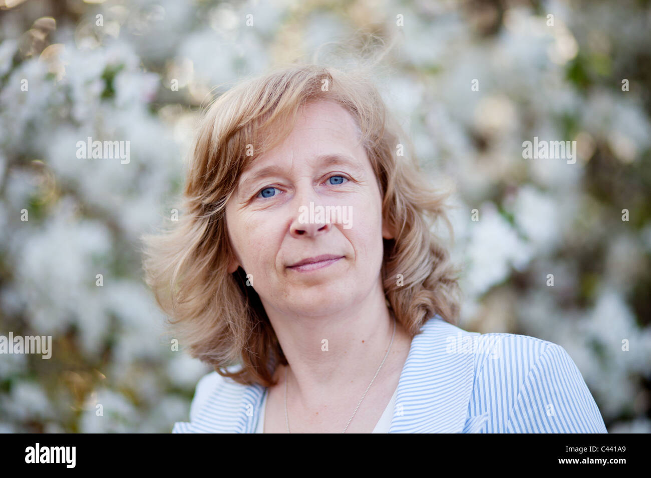 middle-aged woman standing near the apple-tree Stock Photo - Alamy