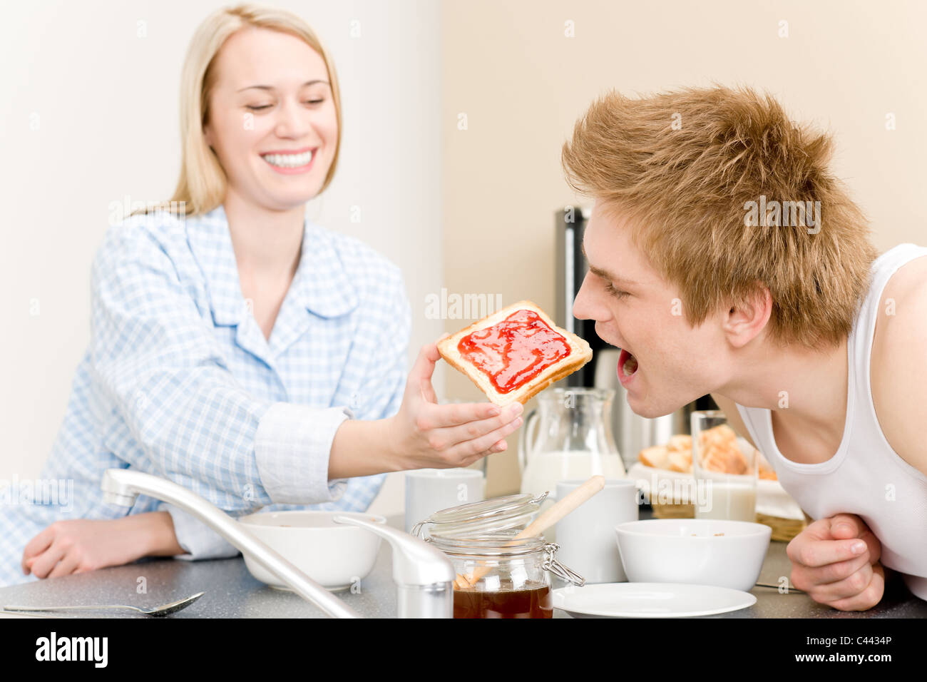 Breakfast happy couple man feed toast to woman in kitchen Stock Photo ...