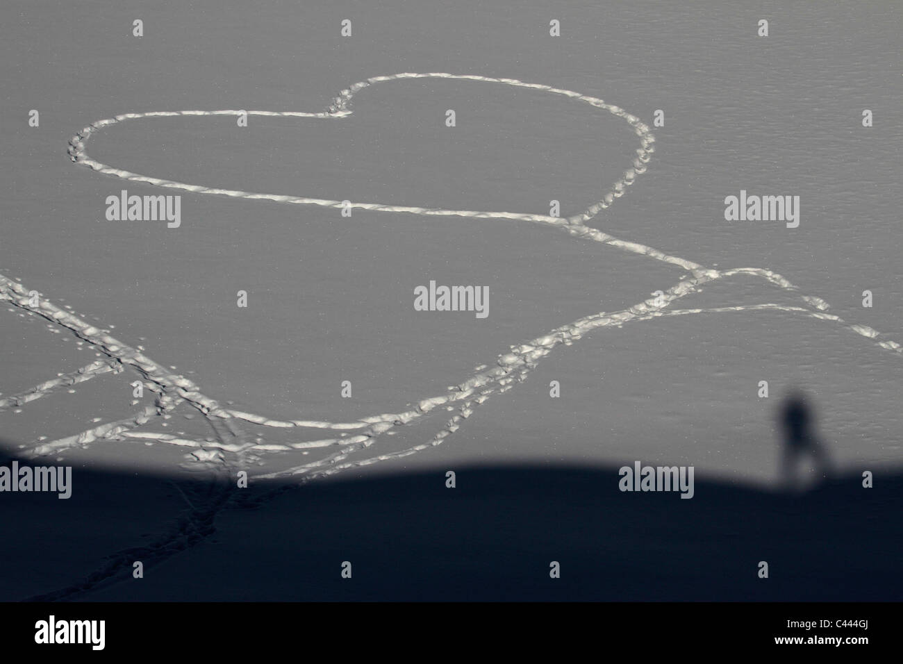 A heart shape stamped out in the snow by footprints Stock Photo - Alamy