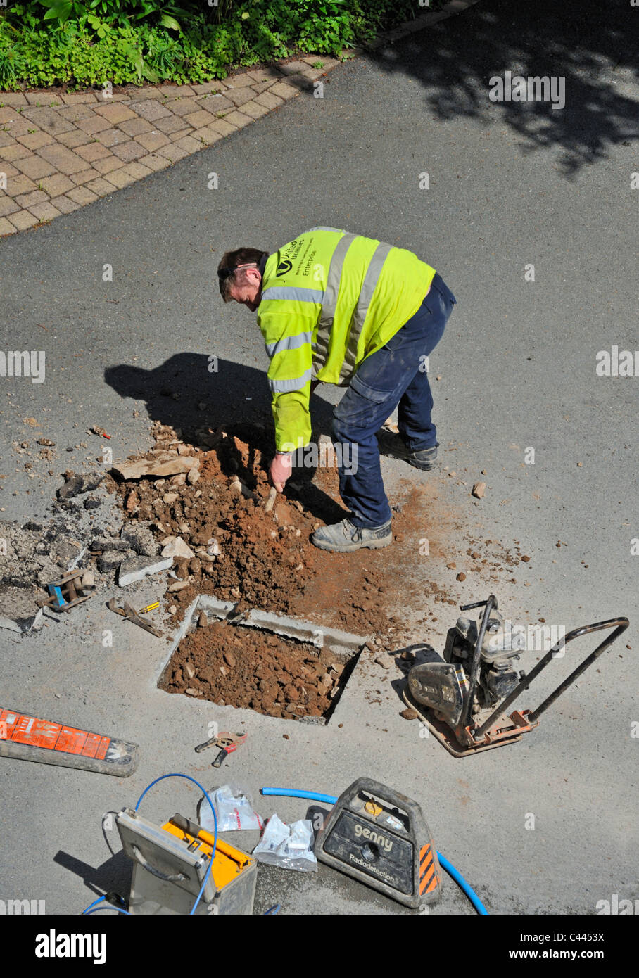 United Utilities operative backfilling excavation after investigating ...