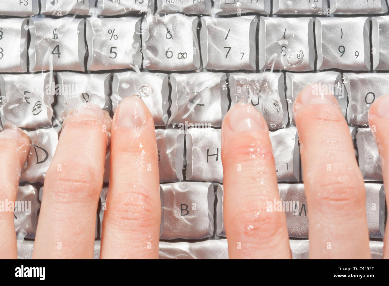 Detail of hands typing on a laptop underwater Stock Photo - Alamy